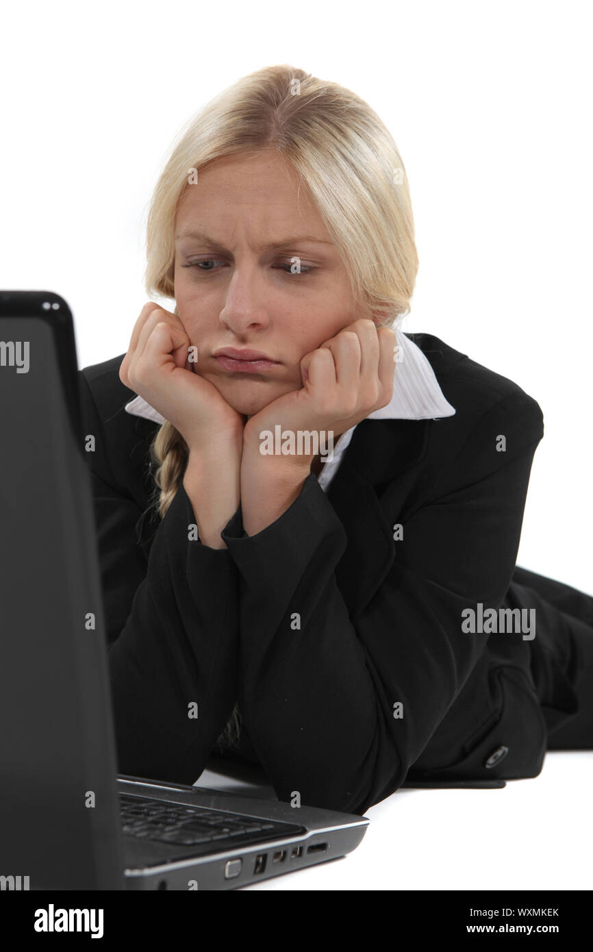 Confused blond office worker using laptop Stock Photo - Alamy