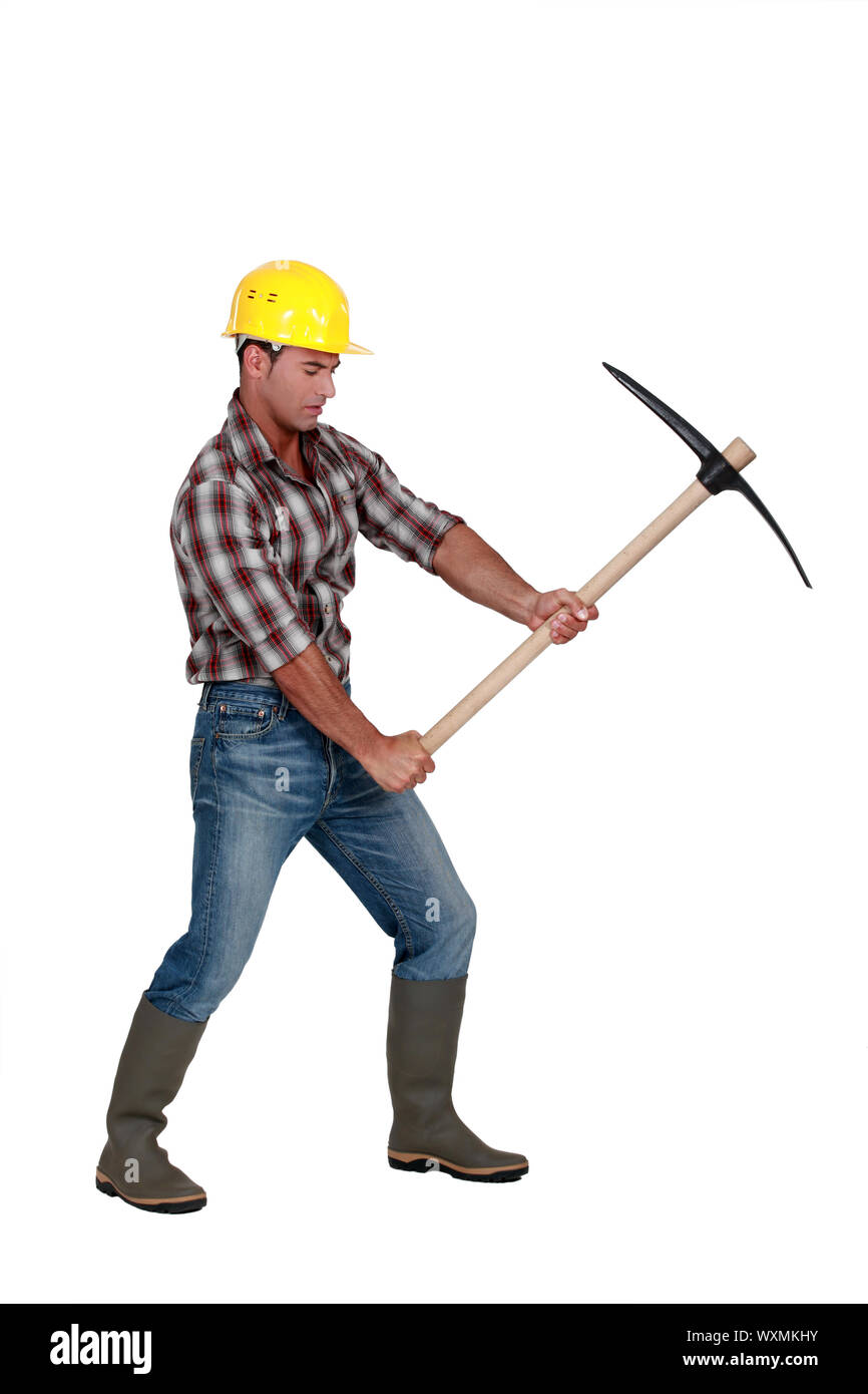 Building worker using a pickaxe, studio shot Stock Photo - Alamy