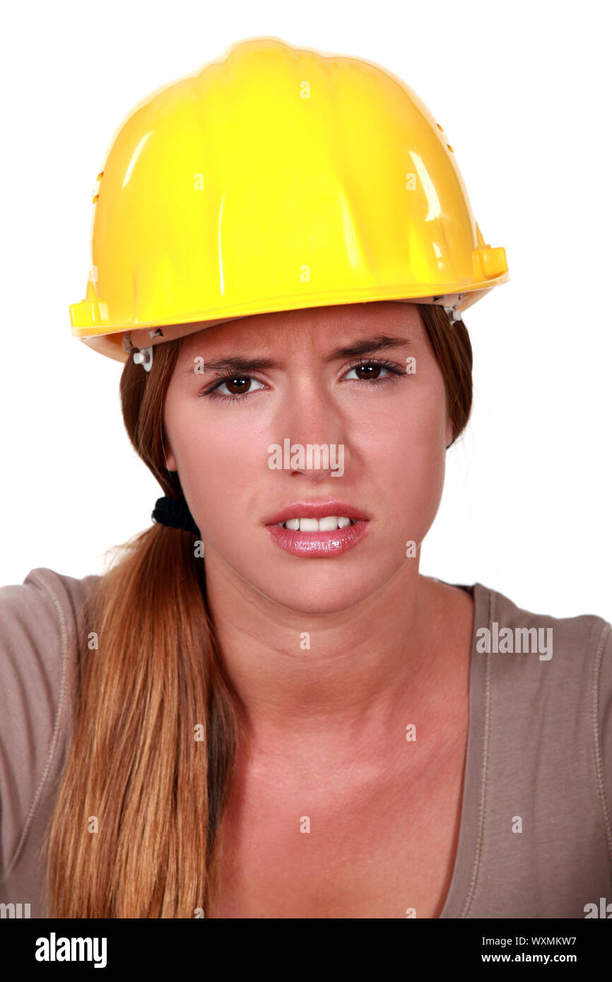 Concerned woman in a hardhat Stock Photo - Alamy