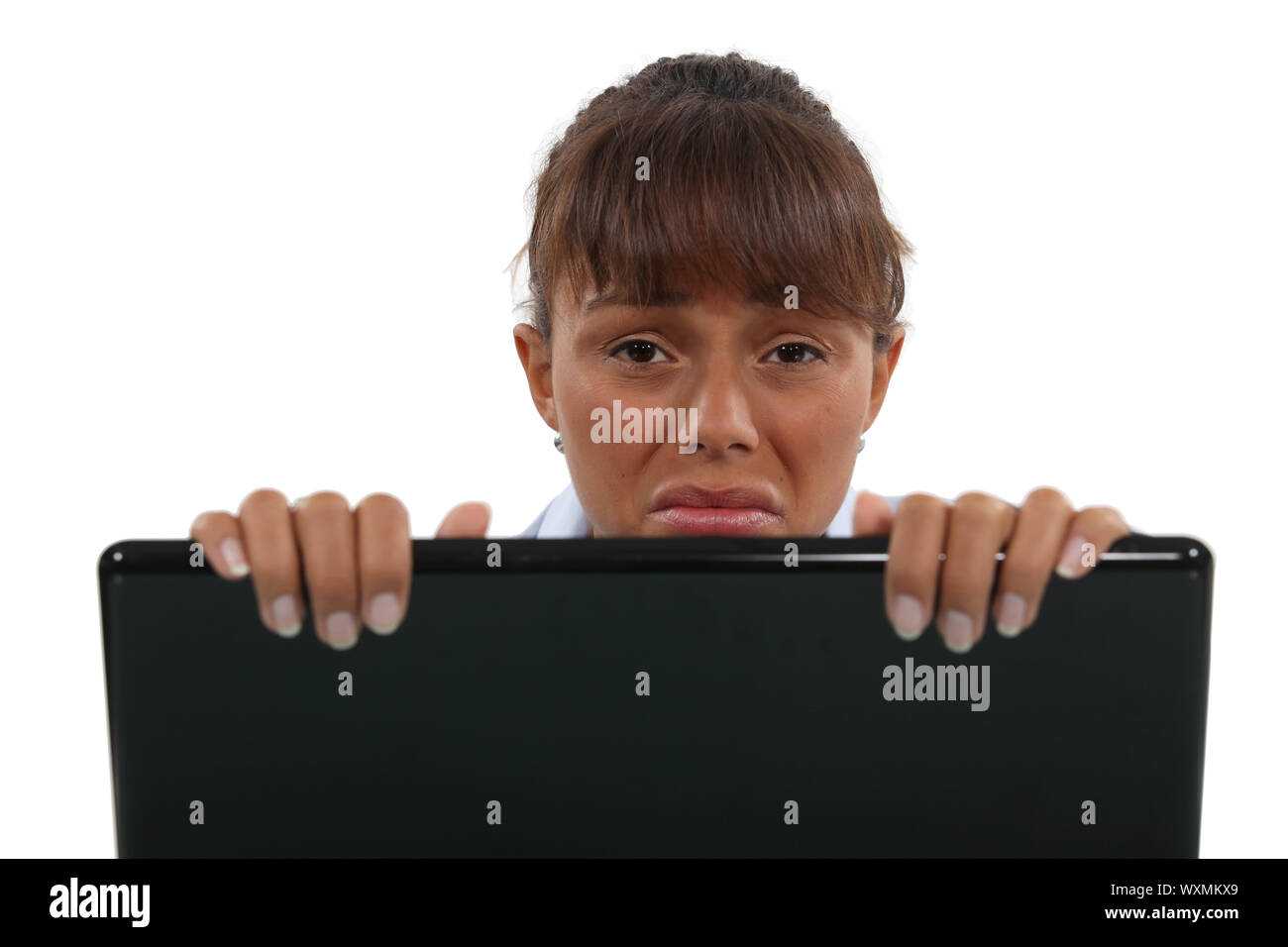 Upset woman behind laptop Stock Photo - Alamy