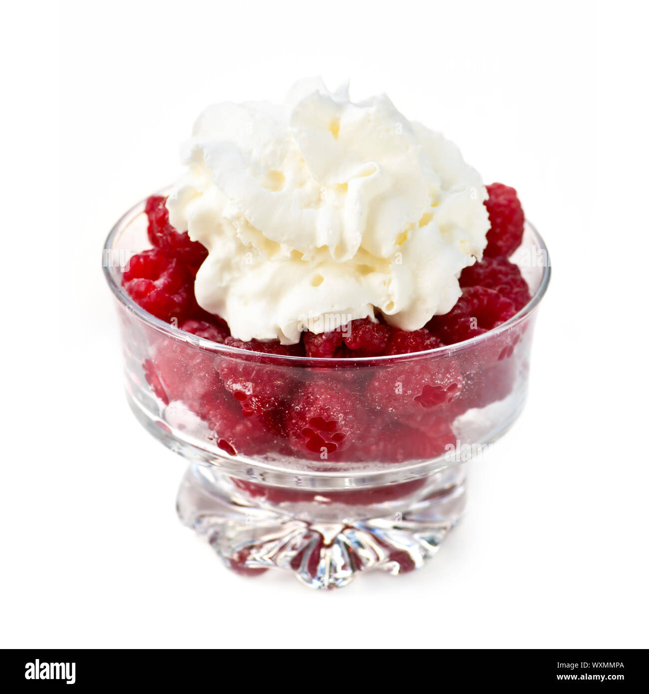 Fresh red raspberries with whipped cream in glass bowl isolated on ...
