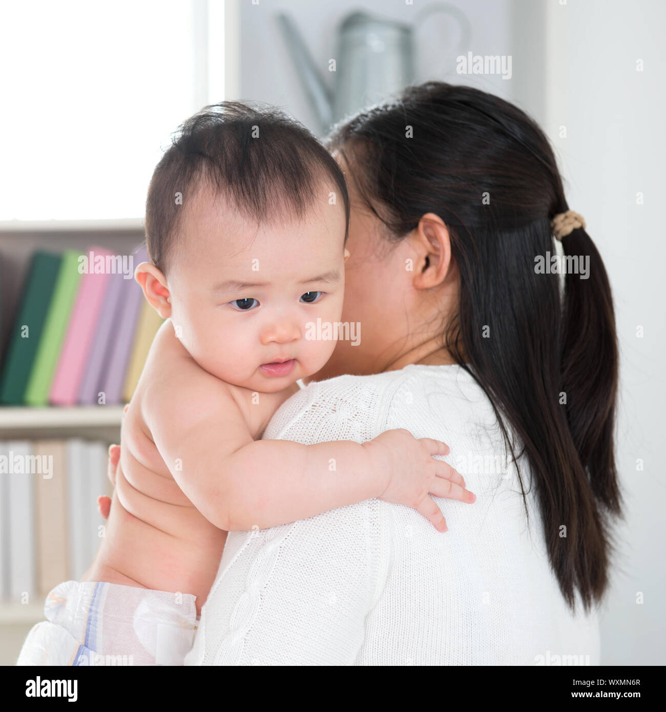 Asian mother pampering six months old baby girl at home Stock Photo - Alamy