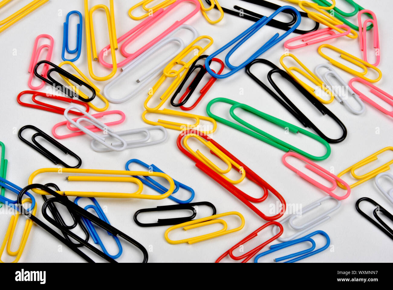 some coloured paper clips and a white background Stock Photo - Alamy