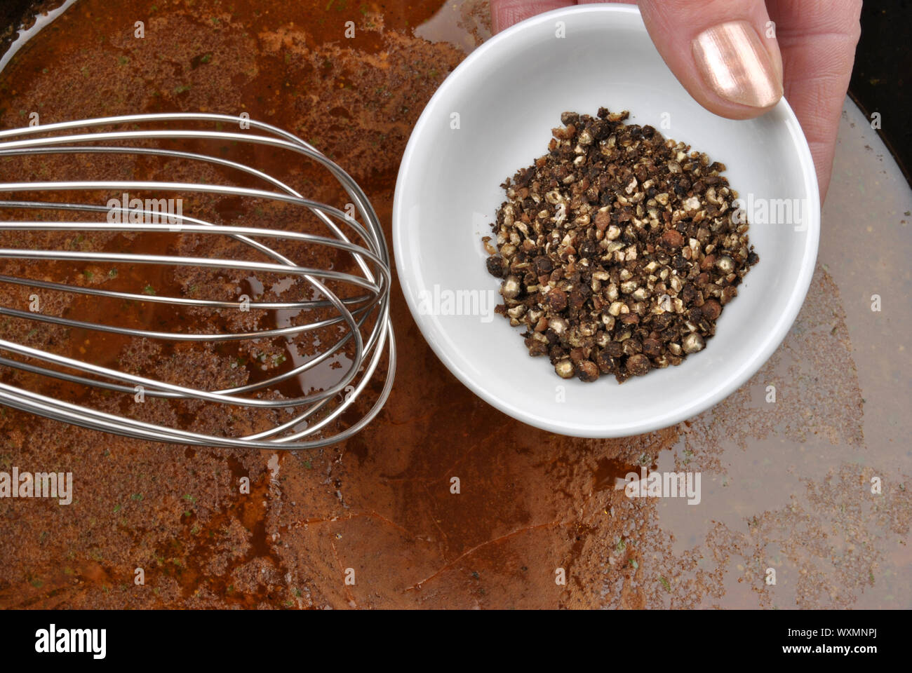 add some organic black pepper into a sauce Stock Photo - Alamy
