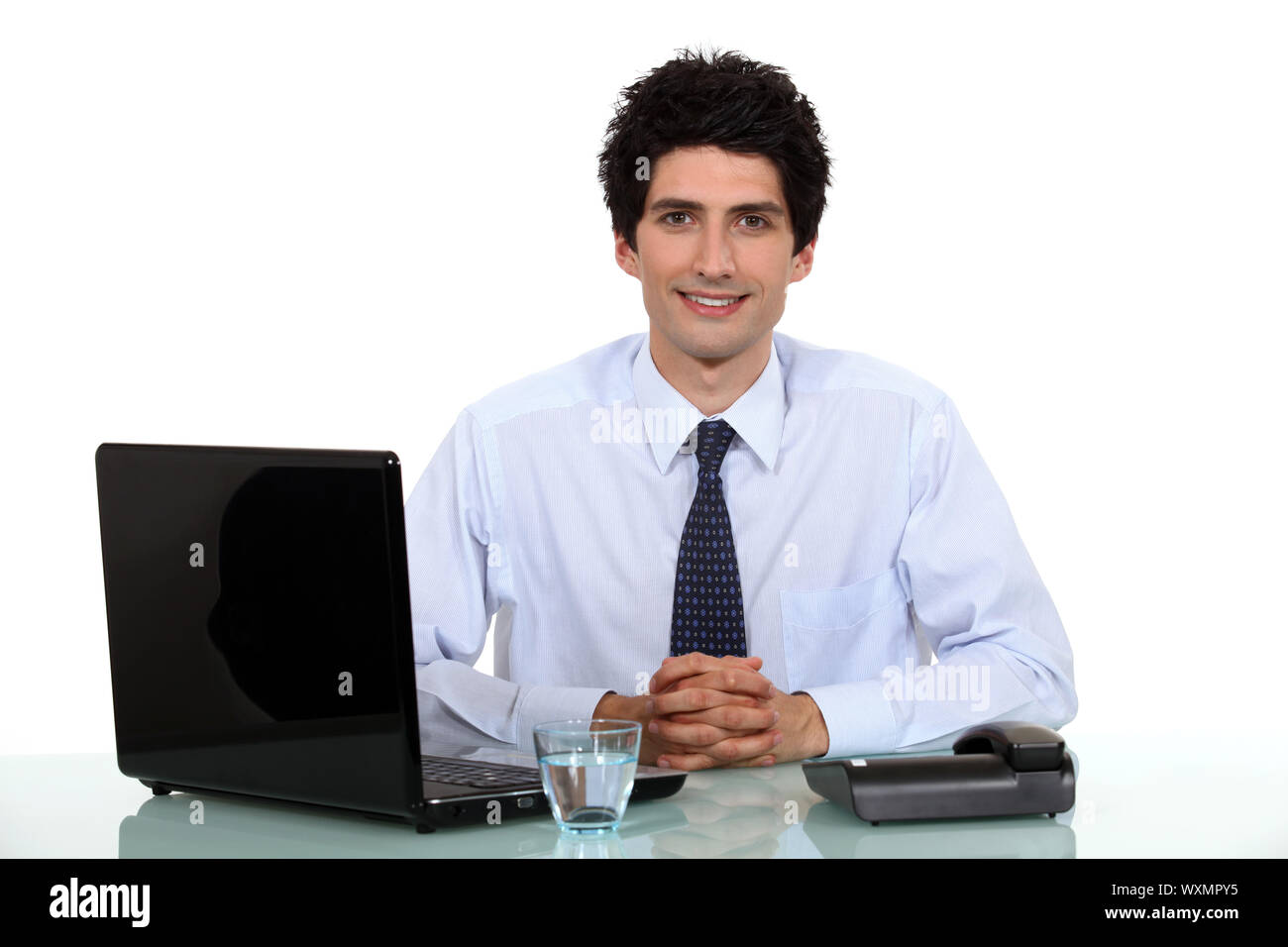 Man sat at desk with glass of water Stock Photo - Alamy