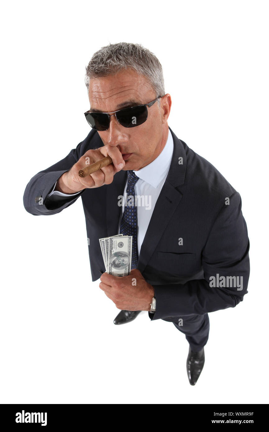 A crook holding stolen money and smoking a cigar Stock Photo - Alamy