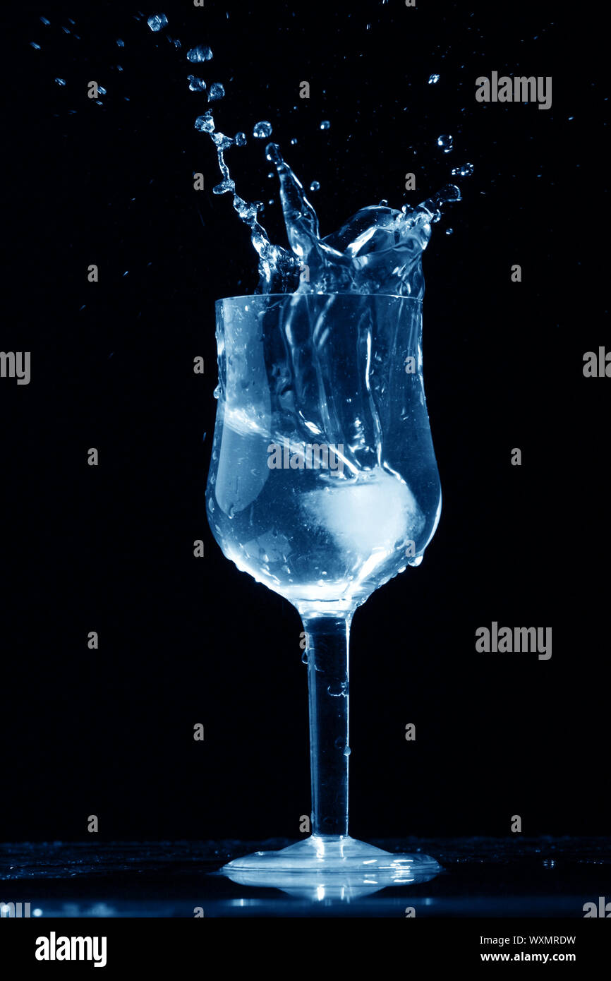 alcohol splash on black background Stock Photo - Alamy