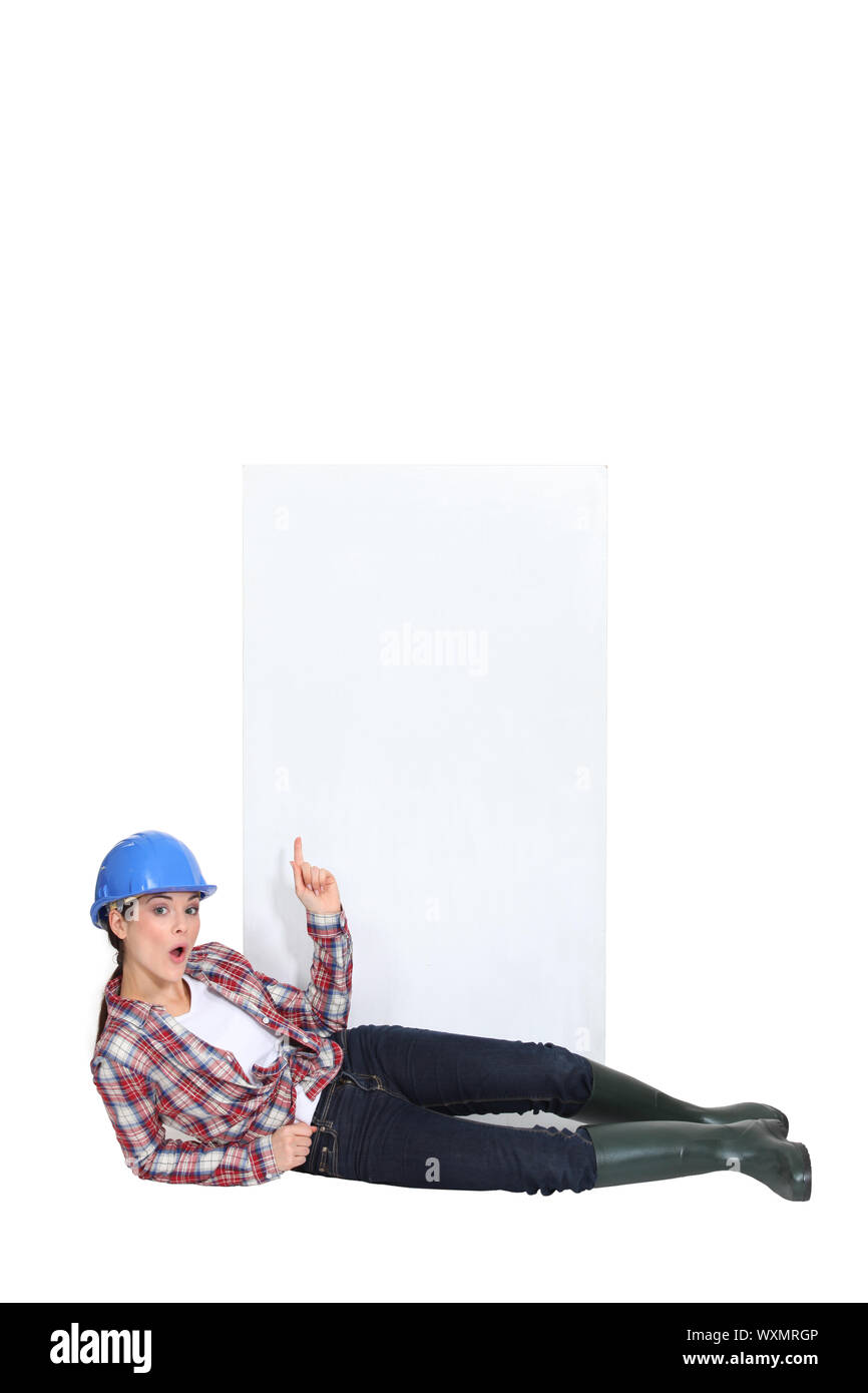 A lying female construction worker pointing at the sky Stock Photo - Alamy
