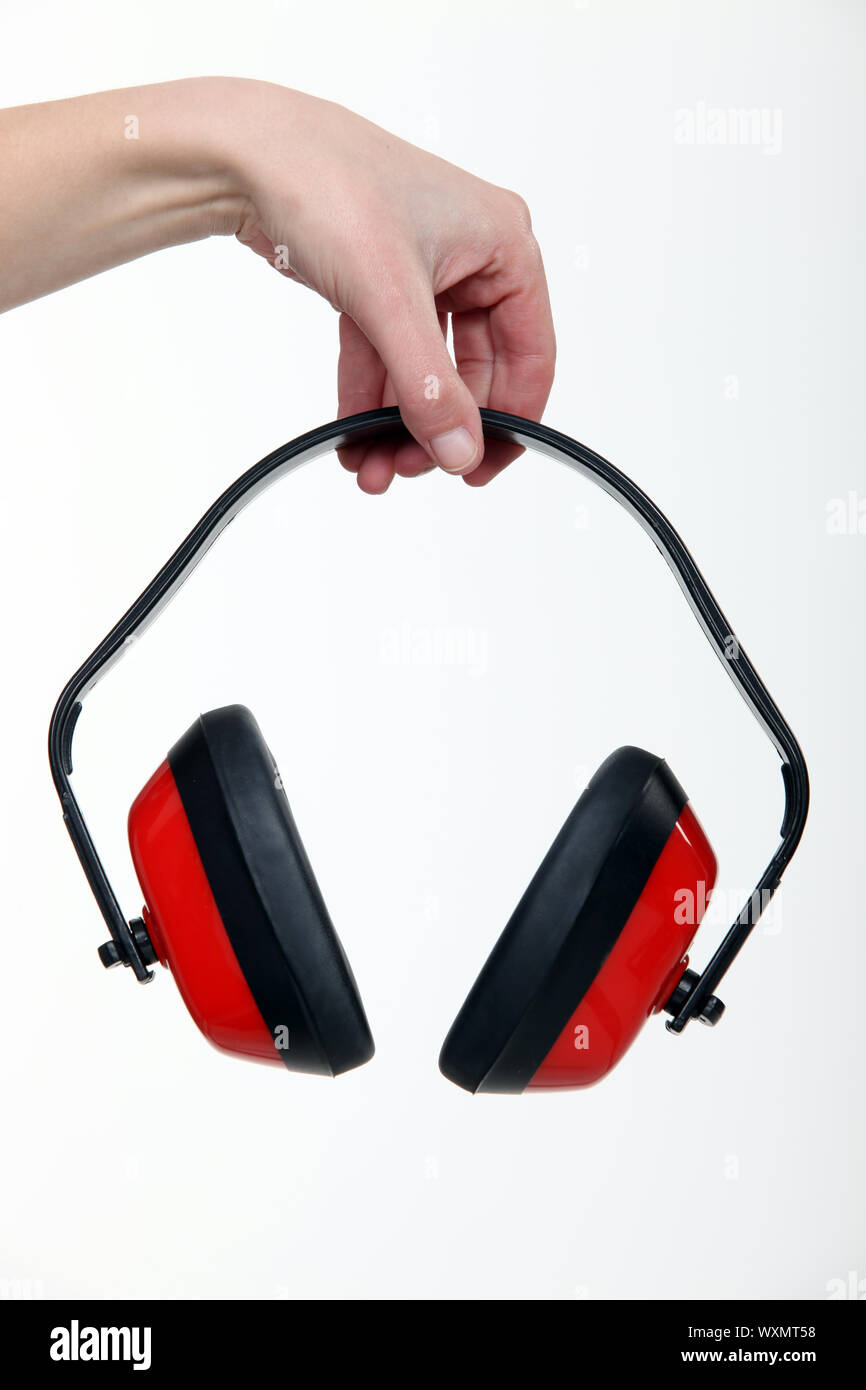 Hand holding a pair of ear defenders Stock Photo - Alamy