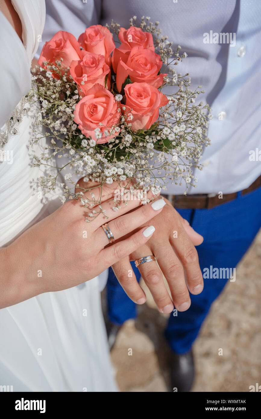 Newlywed couple holding hands and displaying wedding rings, wedding ...
