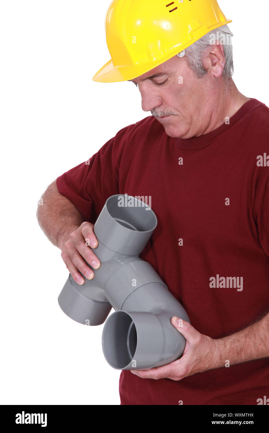 Plumber putting together waste pipes Stock Photo - Alamy