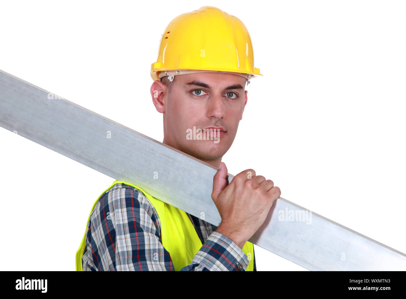 A construction worker carrying a steel plank Stock Photo - Alamy