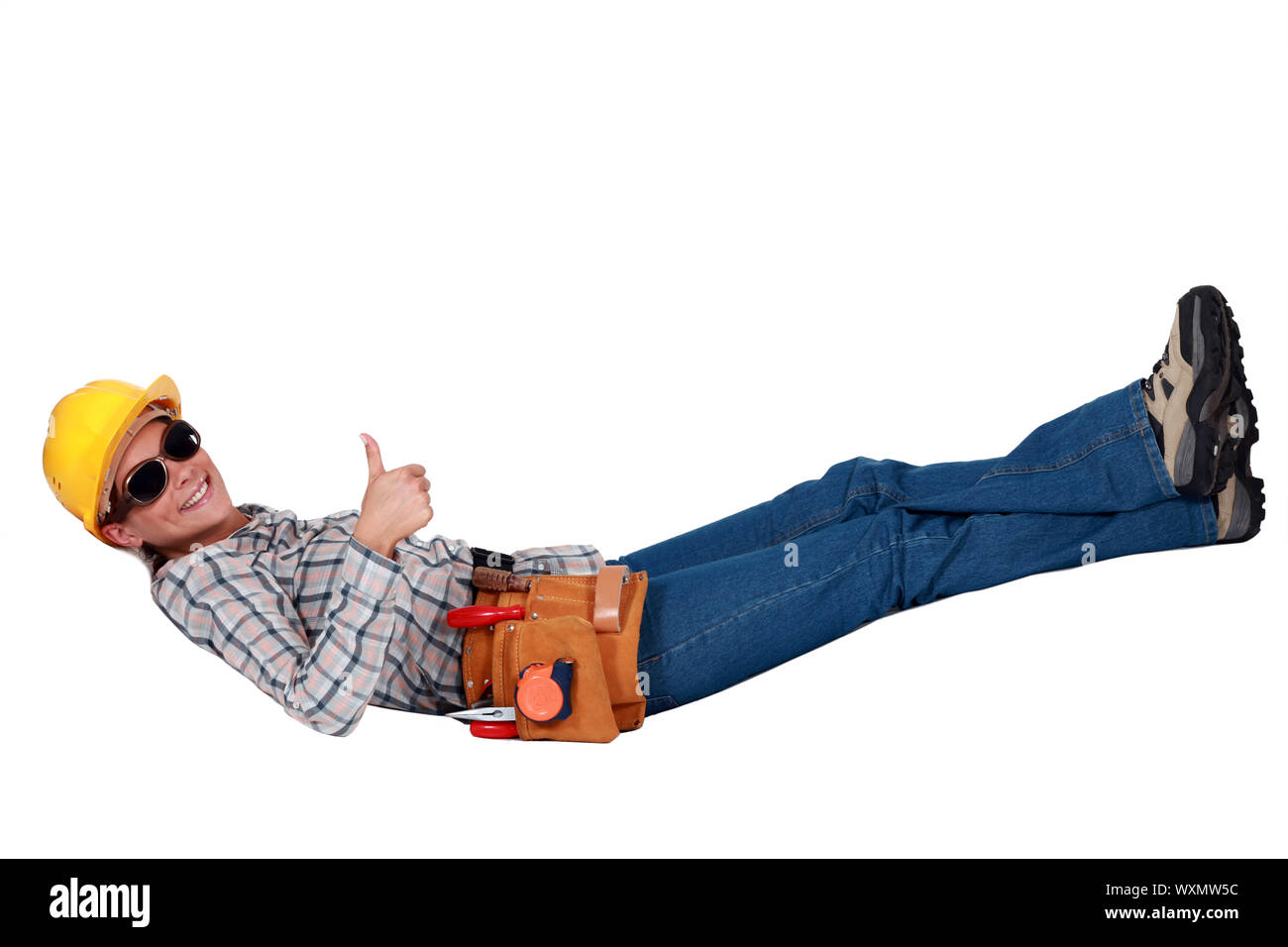 Builder laying down giving thumbs-up Stock Photo - Alamy
