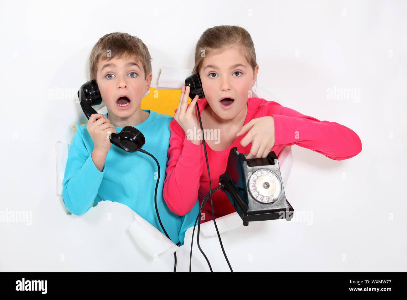 Brother and sister using old telephone Stock Photo - Alamy