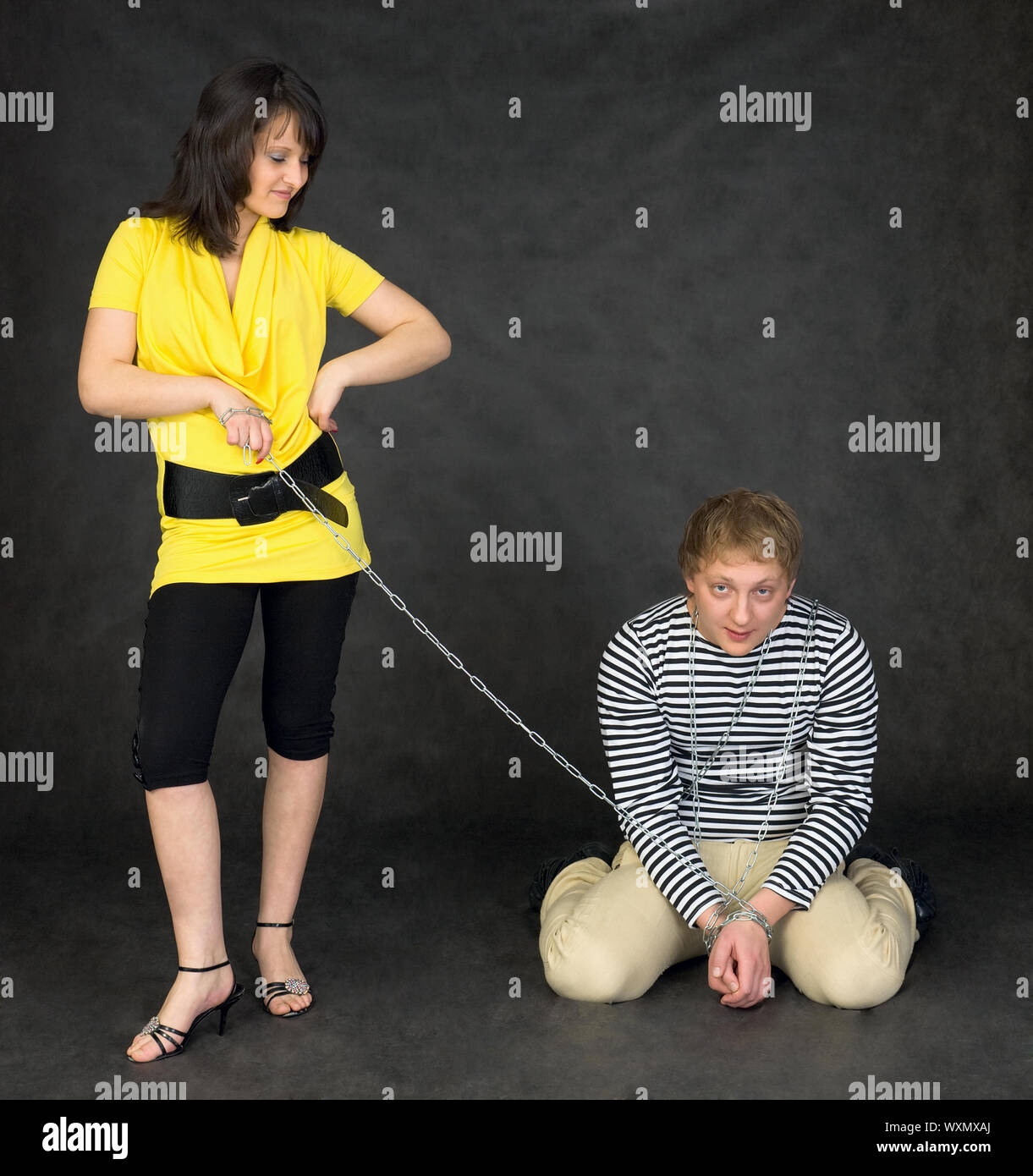 Guy chained in a chain and the girl Stock Photo - Alamy