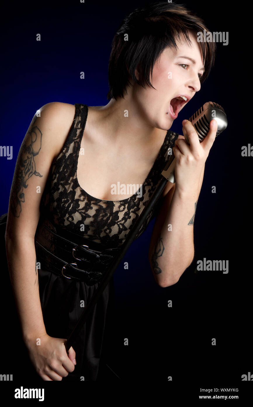 Female singer singing into microphone Stock Photo - Alamy