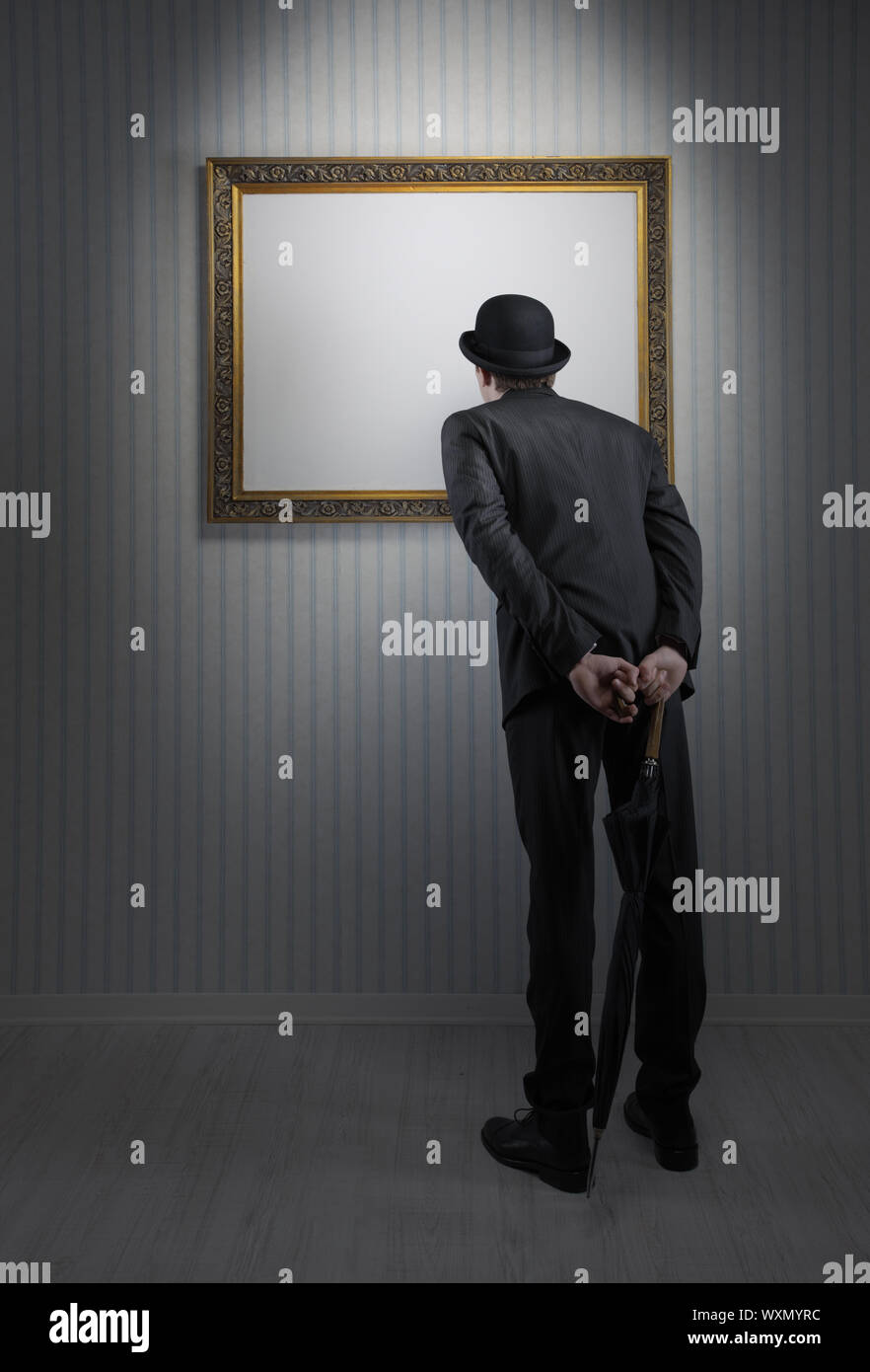 Retro elegant man standing and observing a empty frame in a museum ...