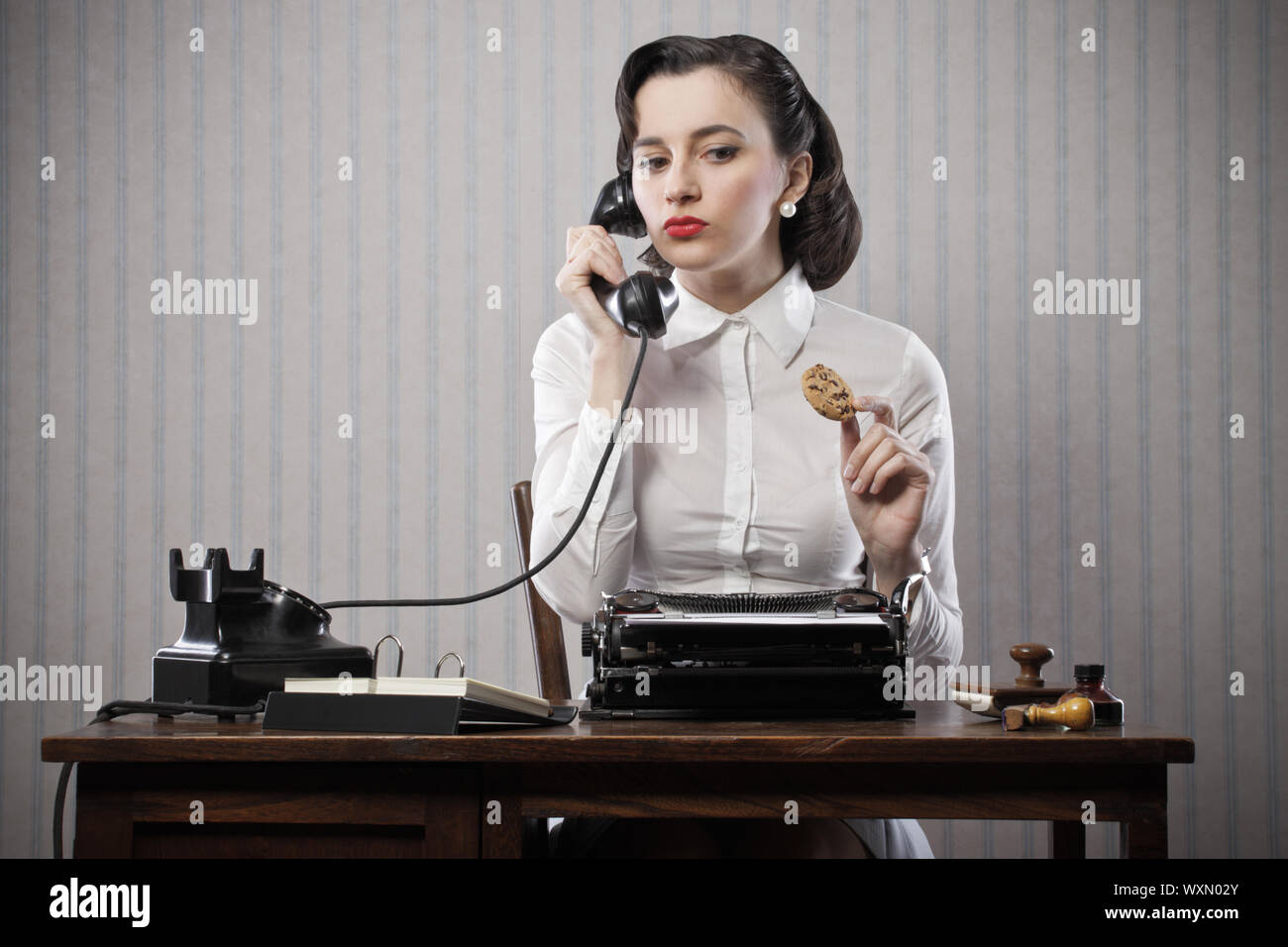 Smiling business woman eating a cookie, break from work Stock Photo - Alamy