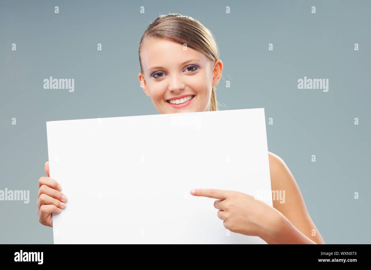 Portrait of a beautiful girl pointing at copy space Stock Photo - Alamy