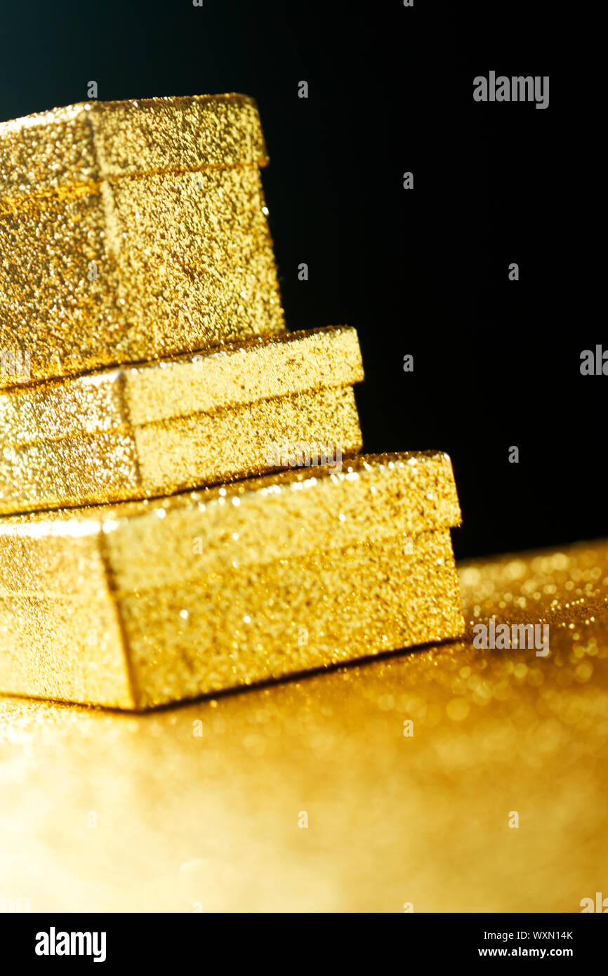 Golden boxes with holiday gifts on shiny glitter background Stock Photo ...