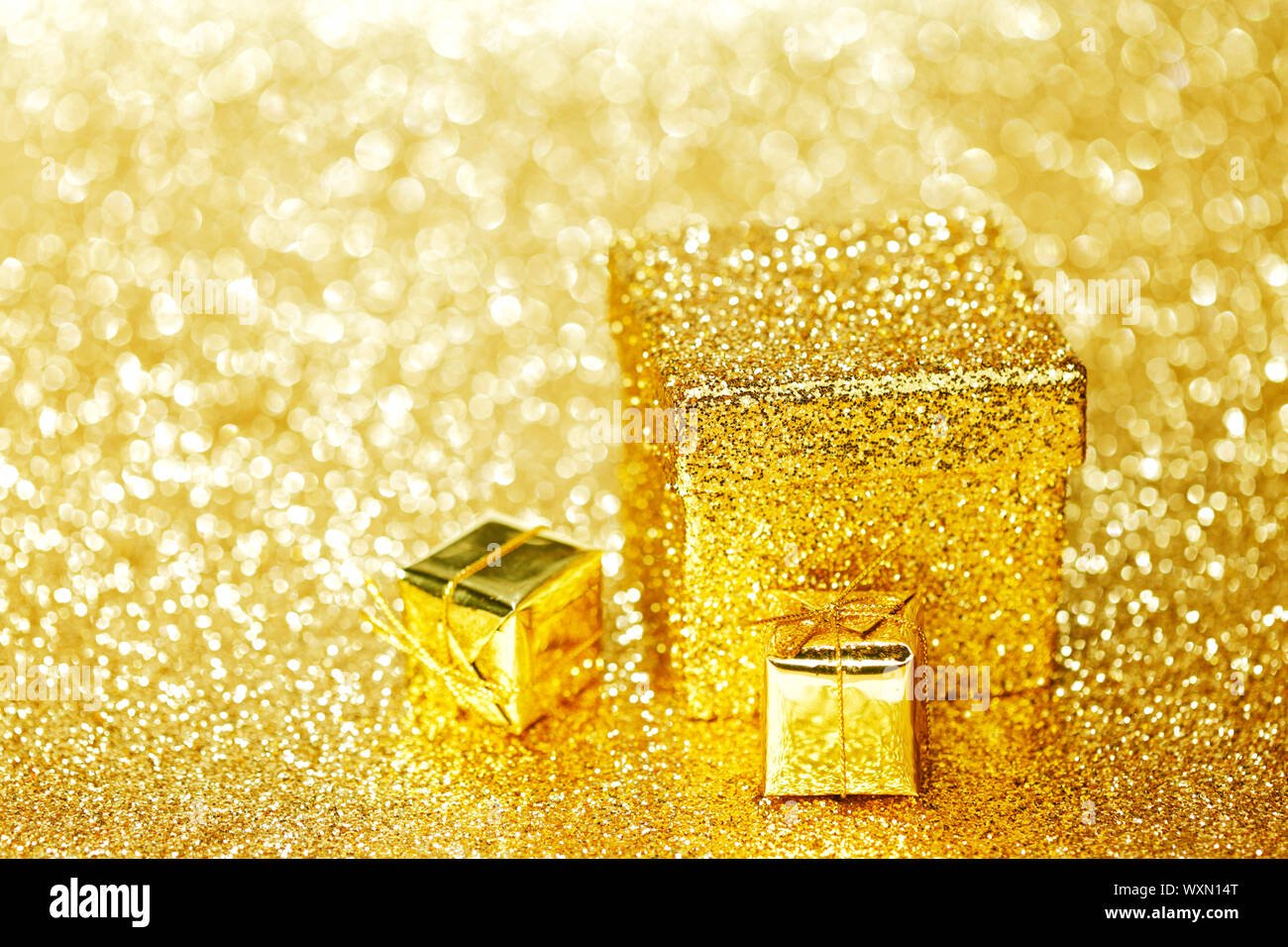 Golden boxes with holiday gifts on shiny glitter background Stock Photo ...