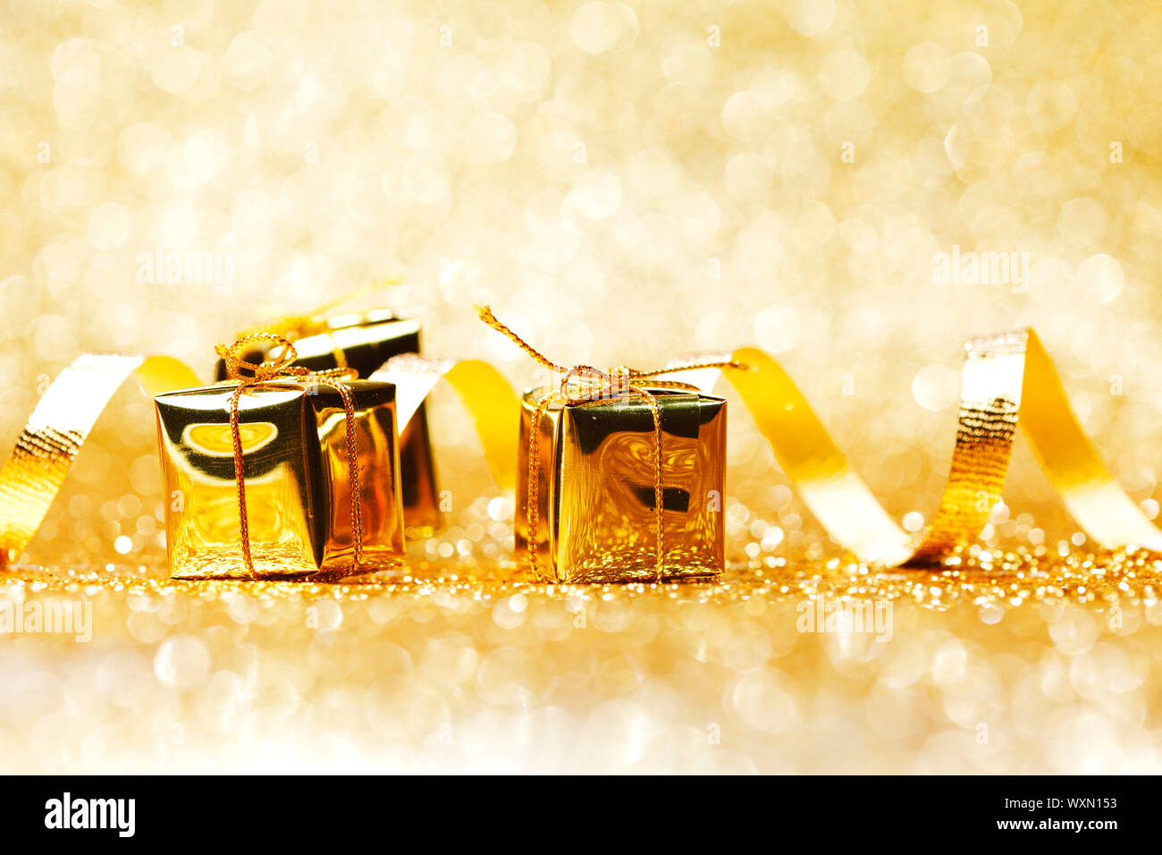 Golden gifts and ribbon decoration on shiny background Stock Photo - Alamy