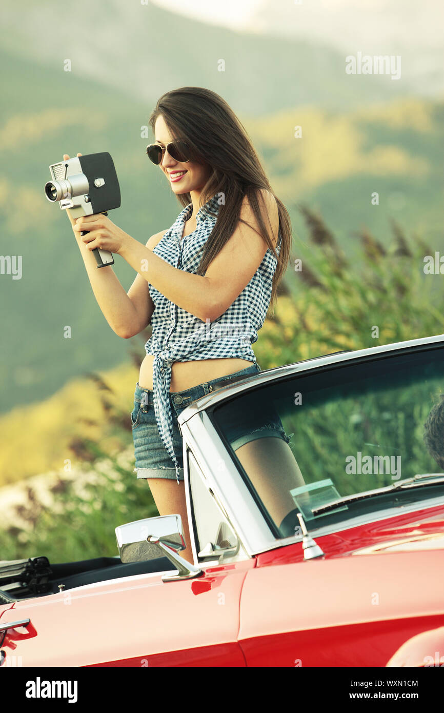 Fashion model with a vintage movie camera in a convertible car Stock ...