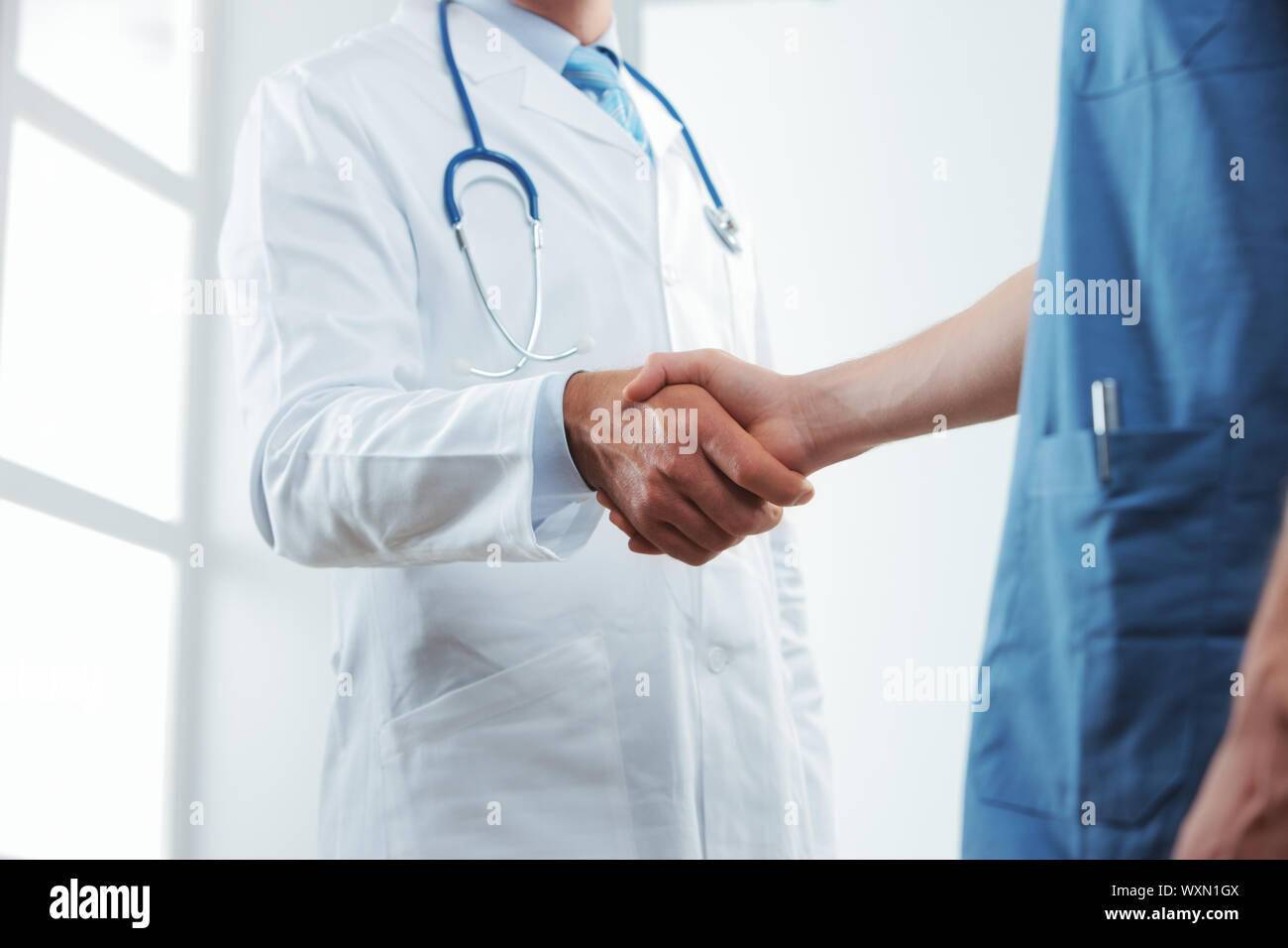 Two medical people handshaking at office Stock Photo - Alamy