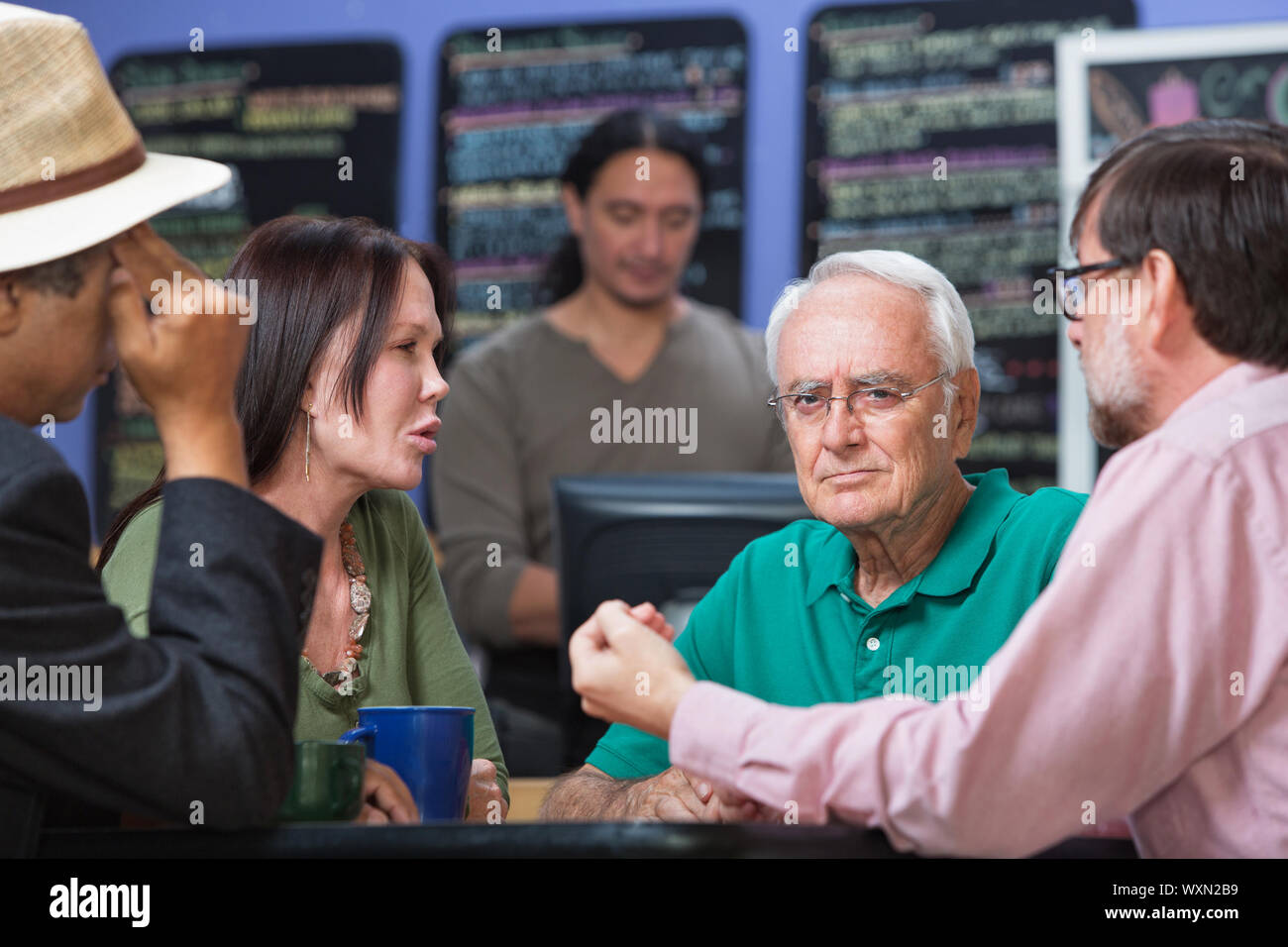 Frowning man with concerned friends in coffee house Stock Photo - Alamy