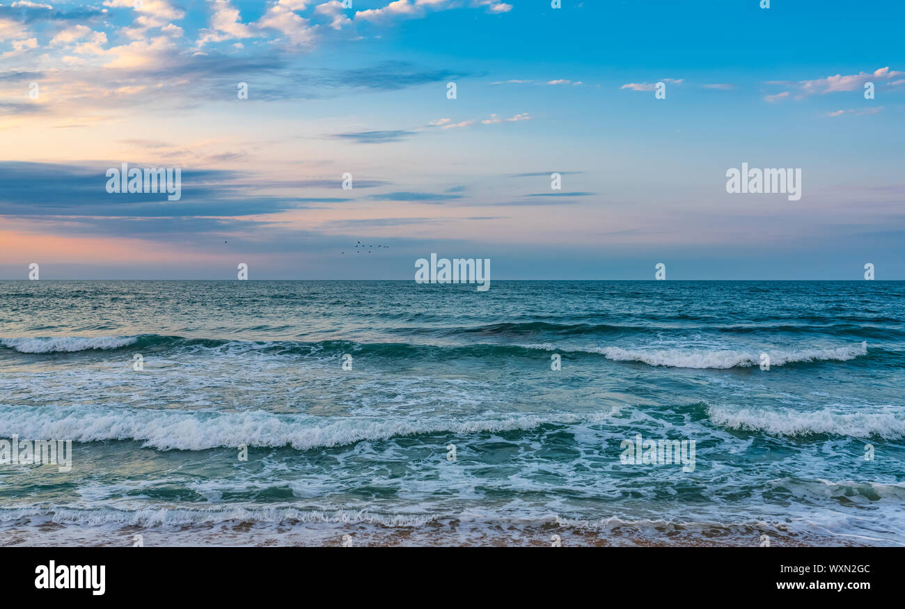 Beach with a wavy beautiful sea Stock Photo - Alamy