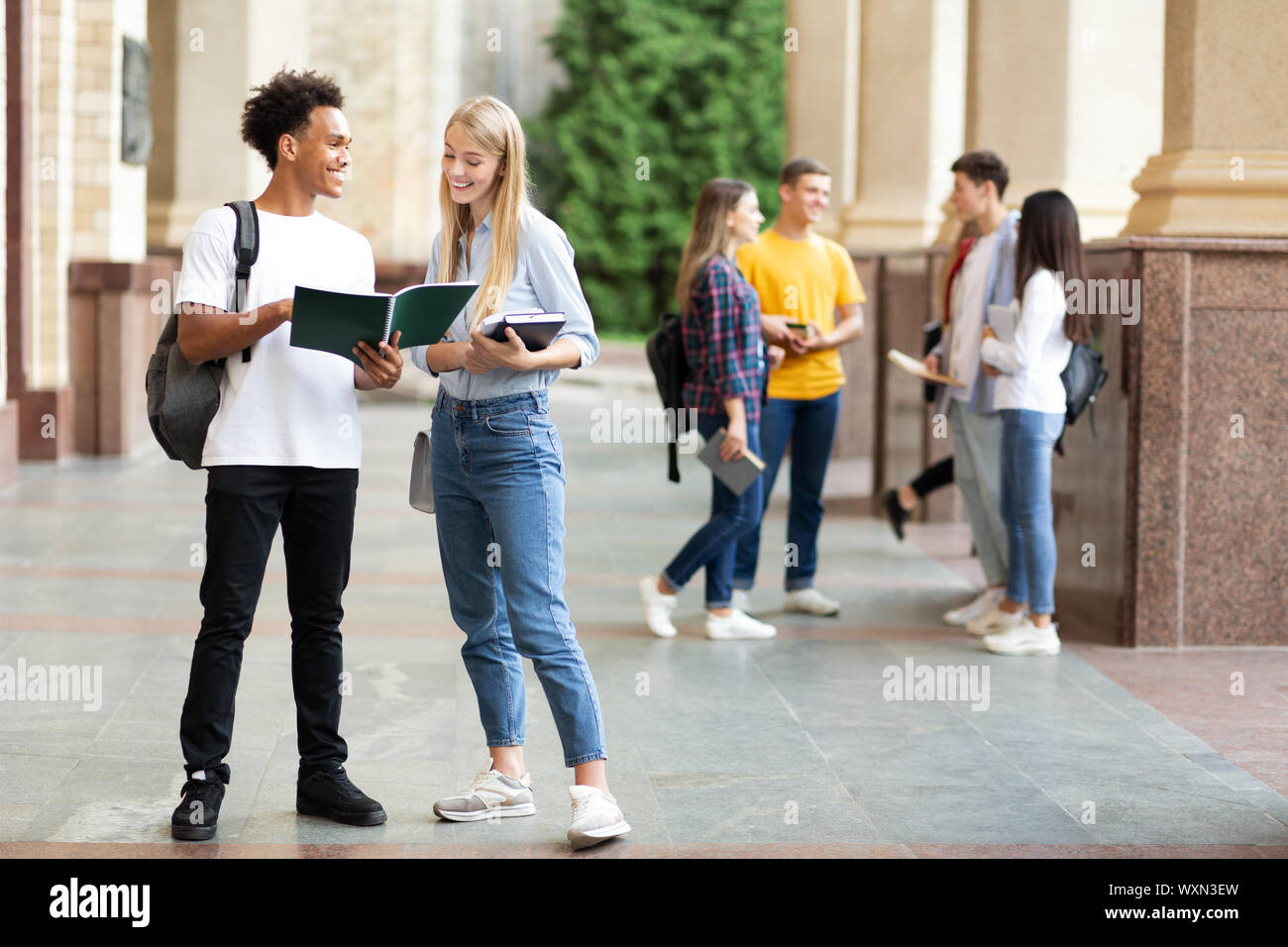 Happy classmates preparing for lecture in university campus Stock Photo ...