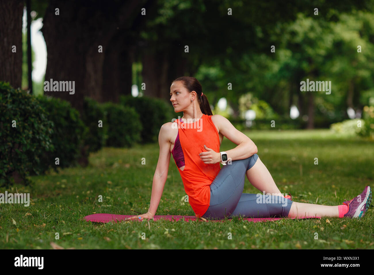 Young fitness woman runner stretching and warming up legs before run. The idea and concept of a ...