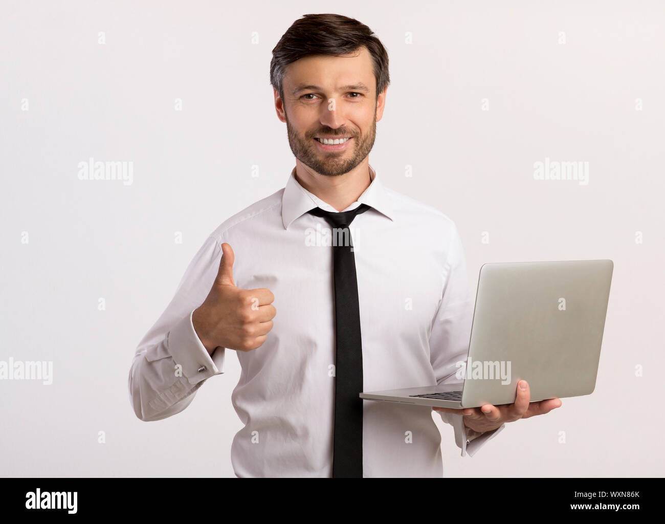 Smiling Man Holding Laptop Gesturing Thumbs-Up, White Background Stock ...