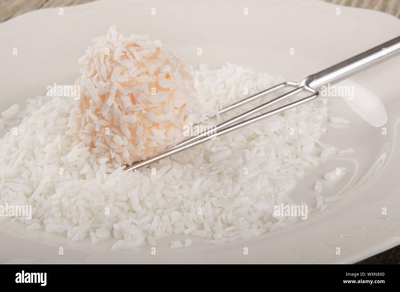 strawberry champagne truffle with coconut flakes on a praline fork ...