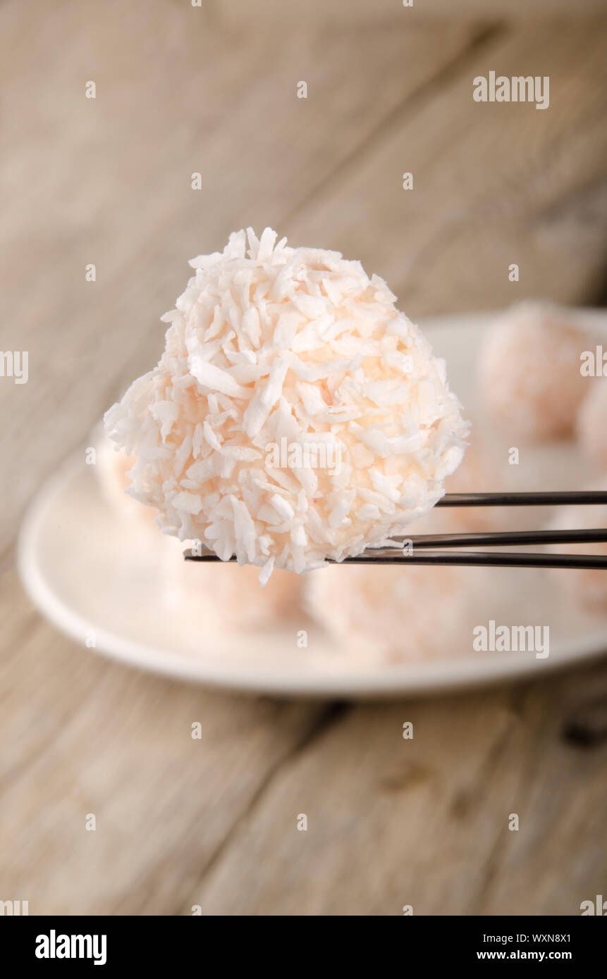 strawberry champagne truffle with coconut flakes on a praline fork ...