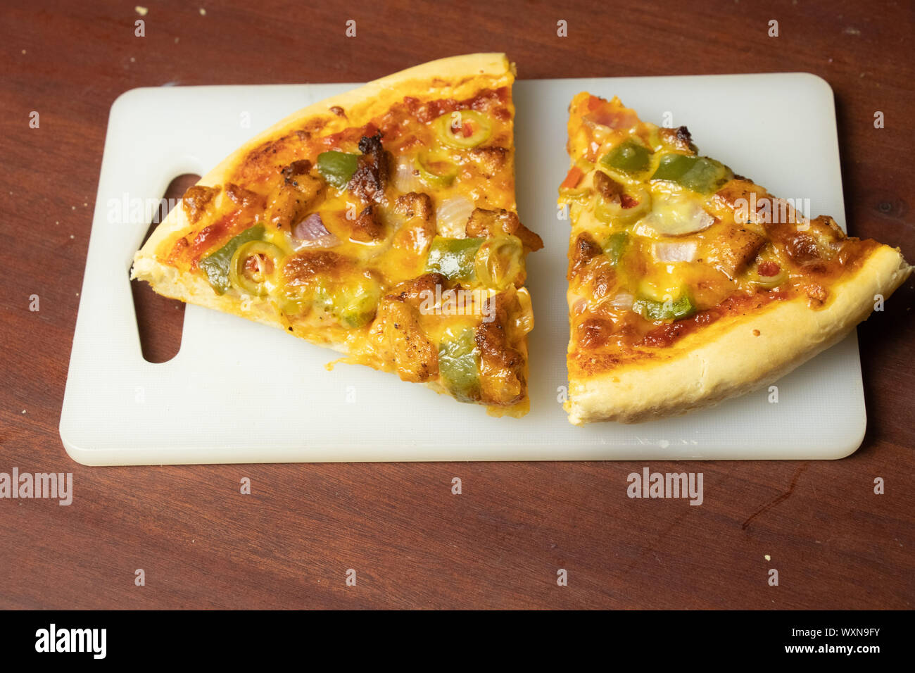 Pan Pizza slice on tray with dark brown wood top closeup Stock Photo ...