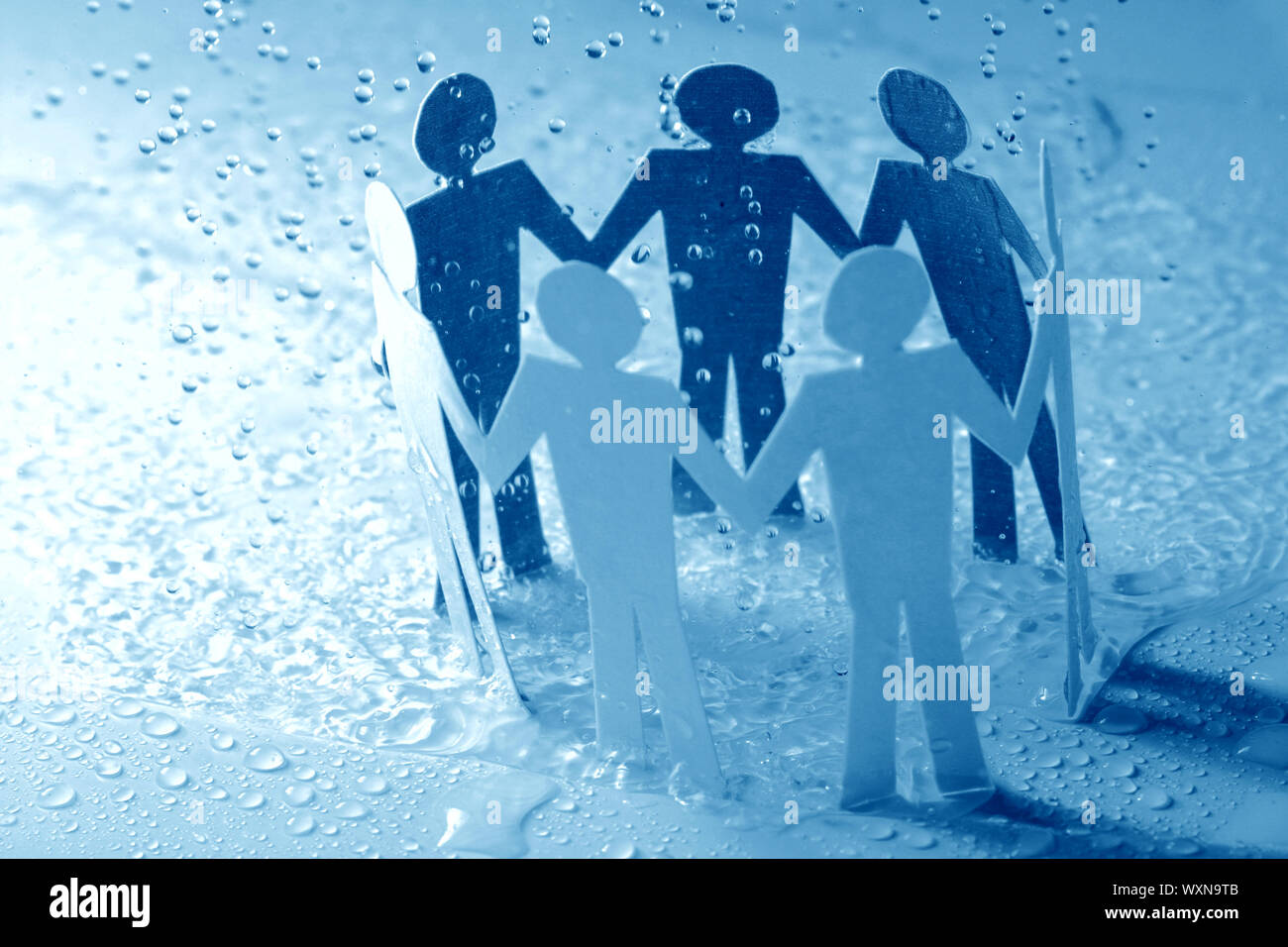 paper team linked together under rain weather concept Stock Photo - Alamy
