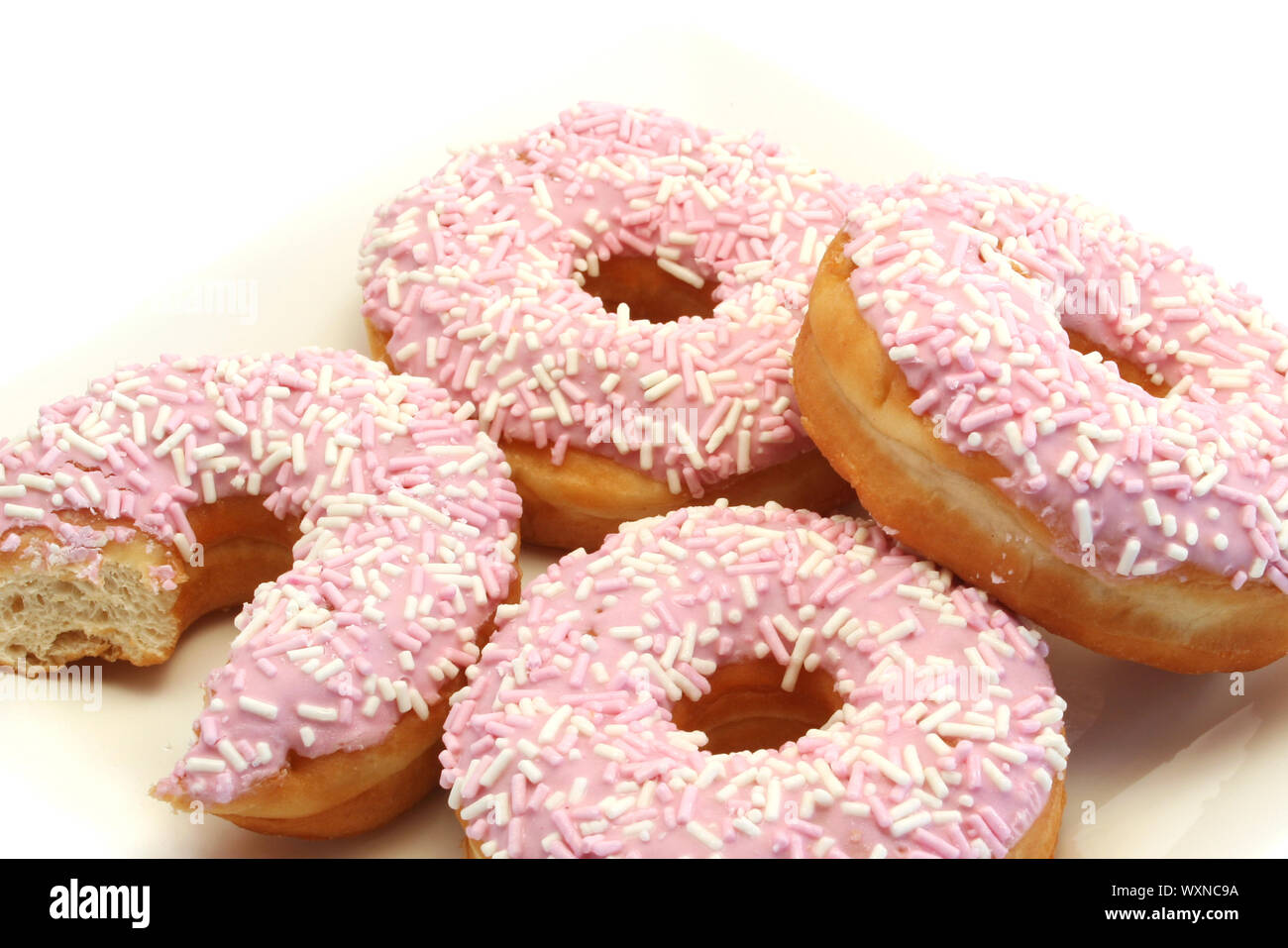 Four Iced Donuts Closeup with a bite taken from one Stock Photo - Alamy