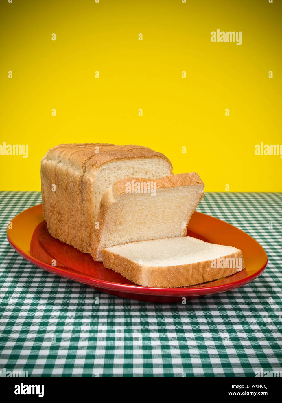 A loaf of sliced bread served on a red platter Stock Photo - Alamy
