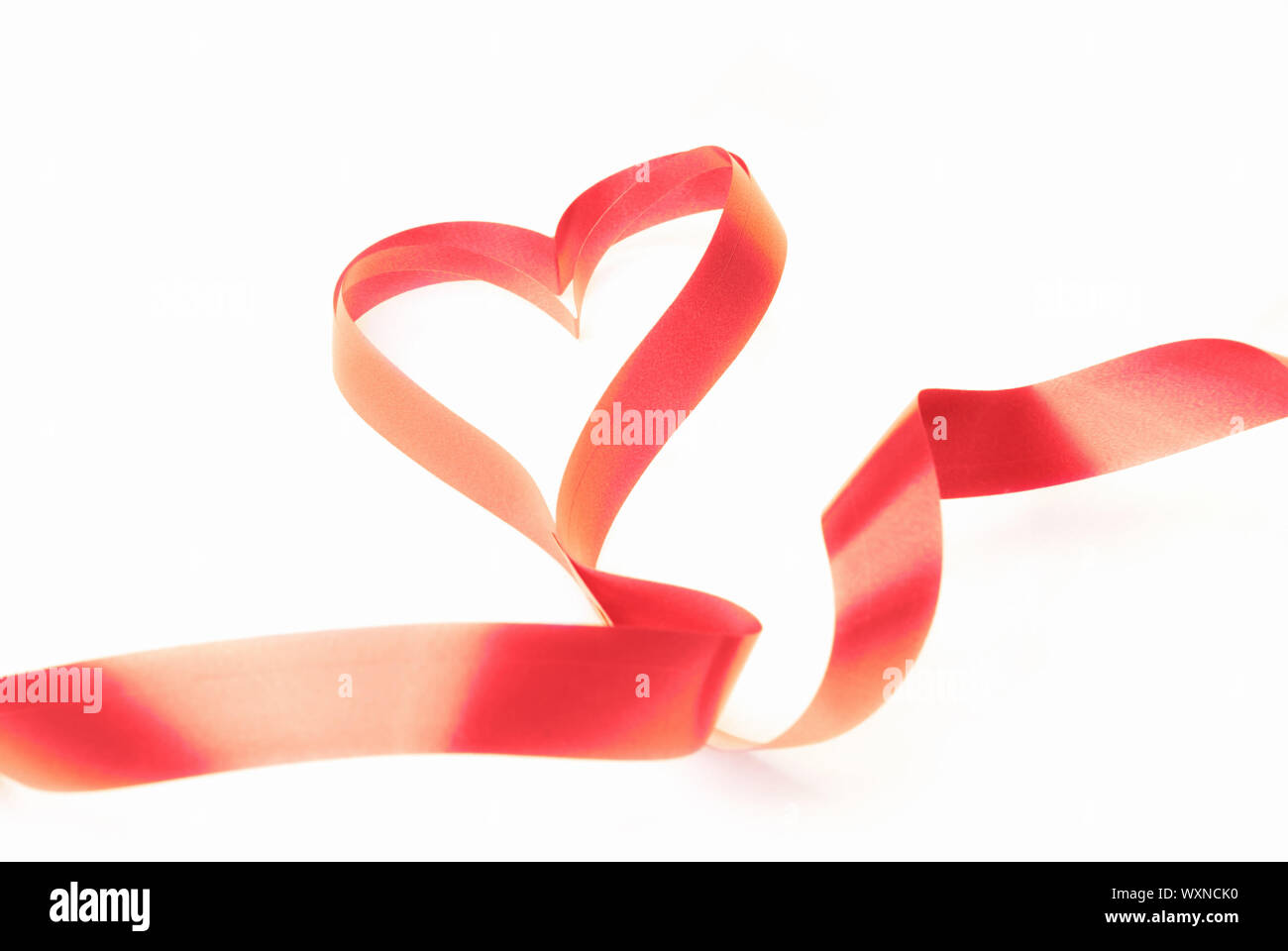 Red ribbon in the shape of heart as a symbol of love Stock Photo - Alamy