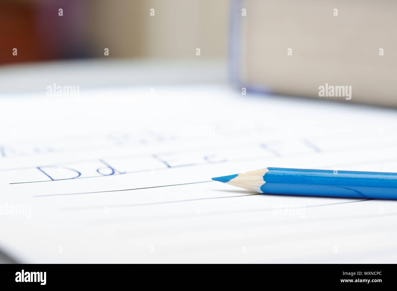 Blue pencil on a paper with alphabet and book Stock Photo - Alamy