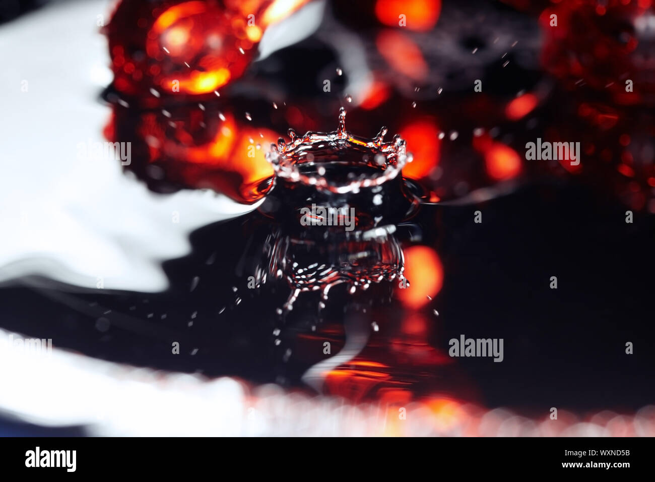 Extremely macro photo of the liquid drop falling on a wet colorful ...