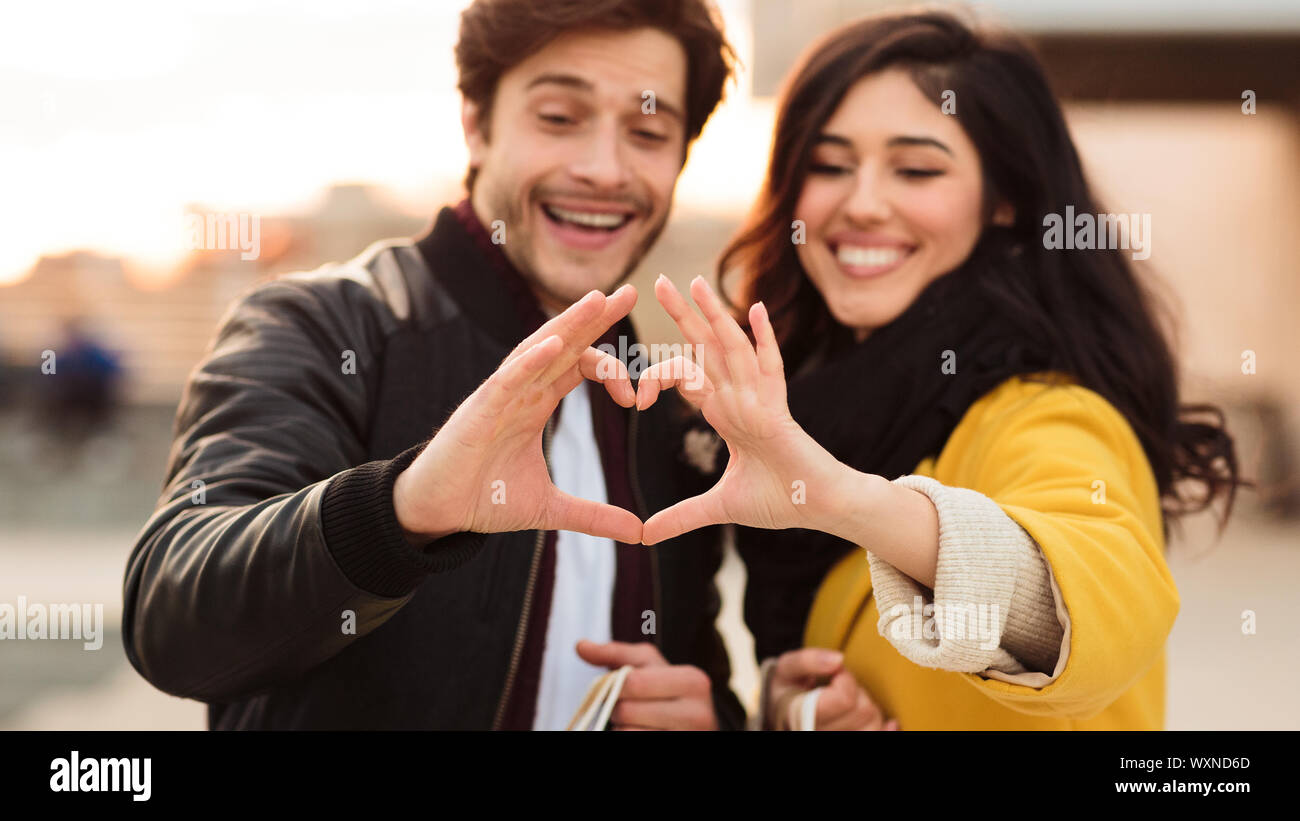 Romantic couple making heart shape with hands Stock Photo - Alamy
