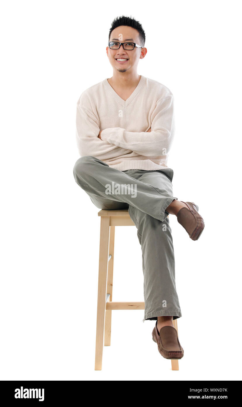 Full body Asian male sitting on a chair isolated over white background ...