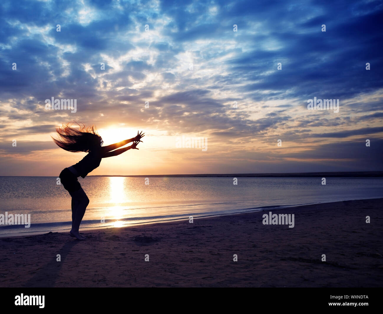 Dancing dynamic woman at the beach during sunset Stock Photo - Alamy