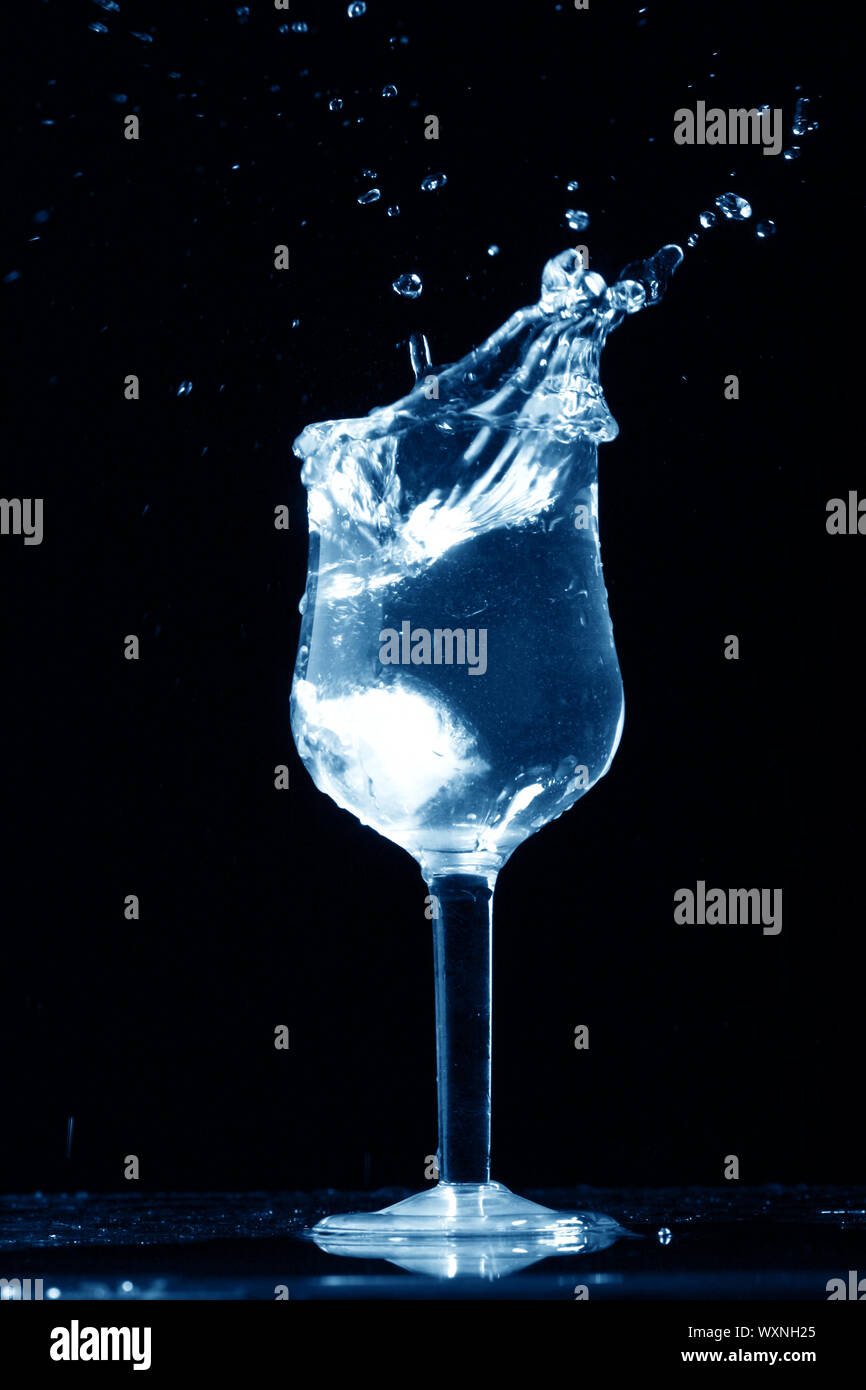 alcohol splash on black background Stock Photo - Alamy