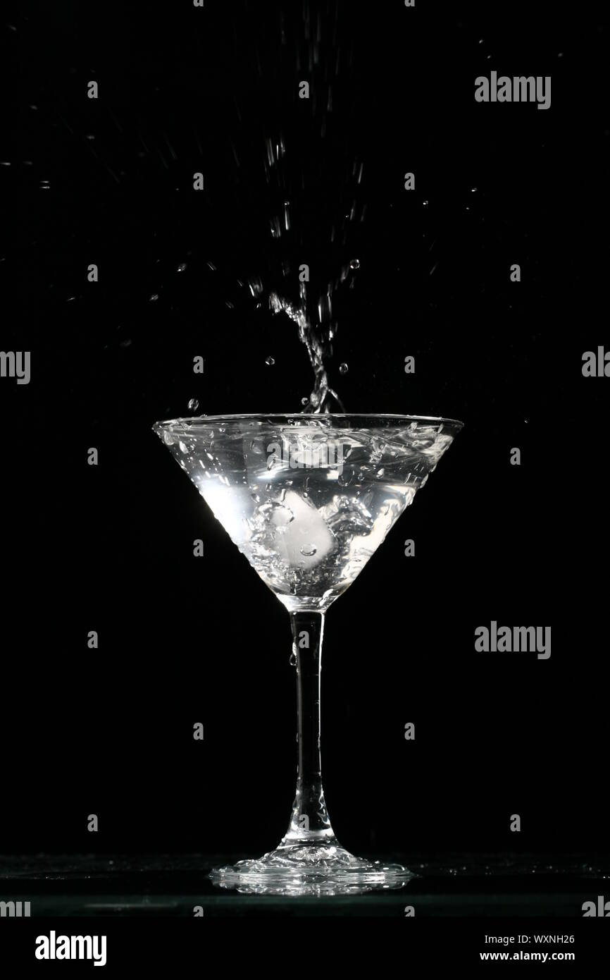 alcohol splash on black background Stock Photo - Alamy