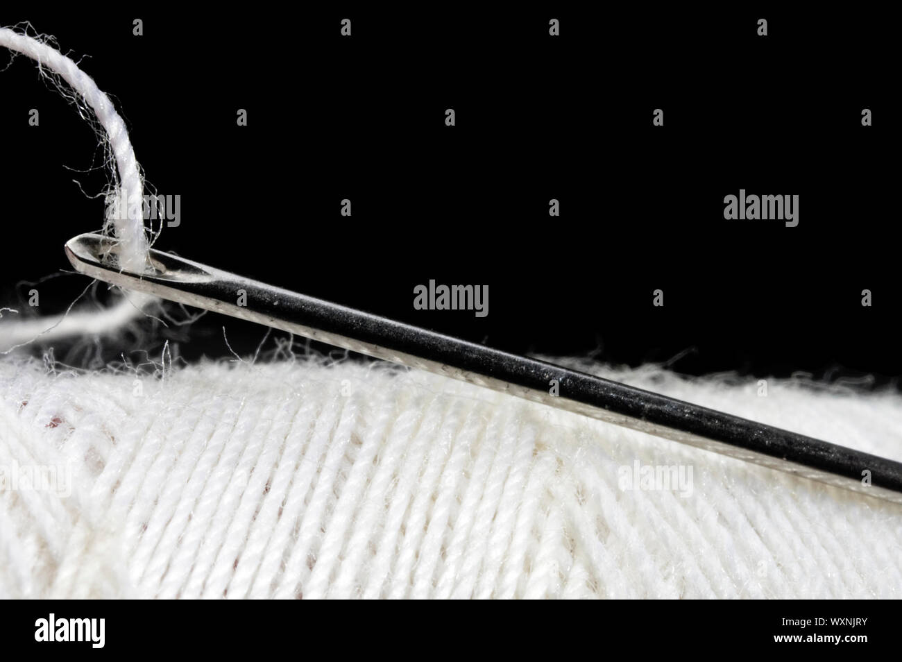 macro shot of needle and thread over black background Stock Photo - Alamy
