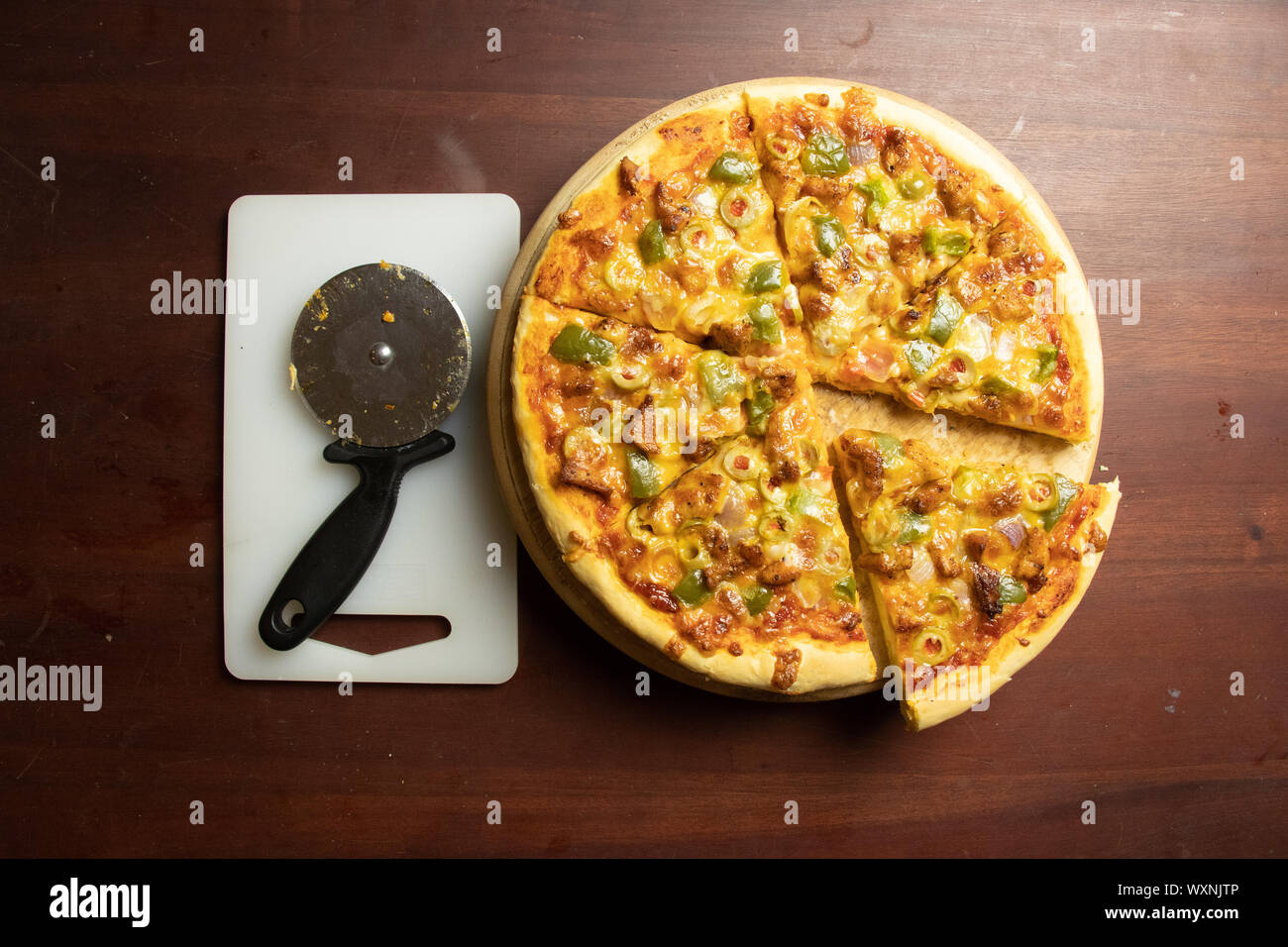 Pan Pizza slice with cutter top side view with dark brown wood Stock ...