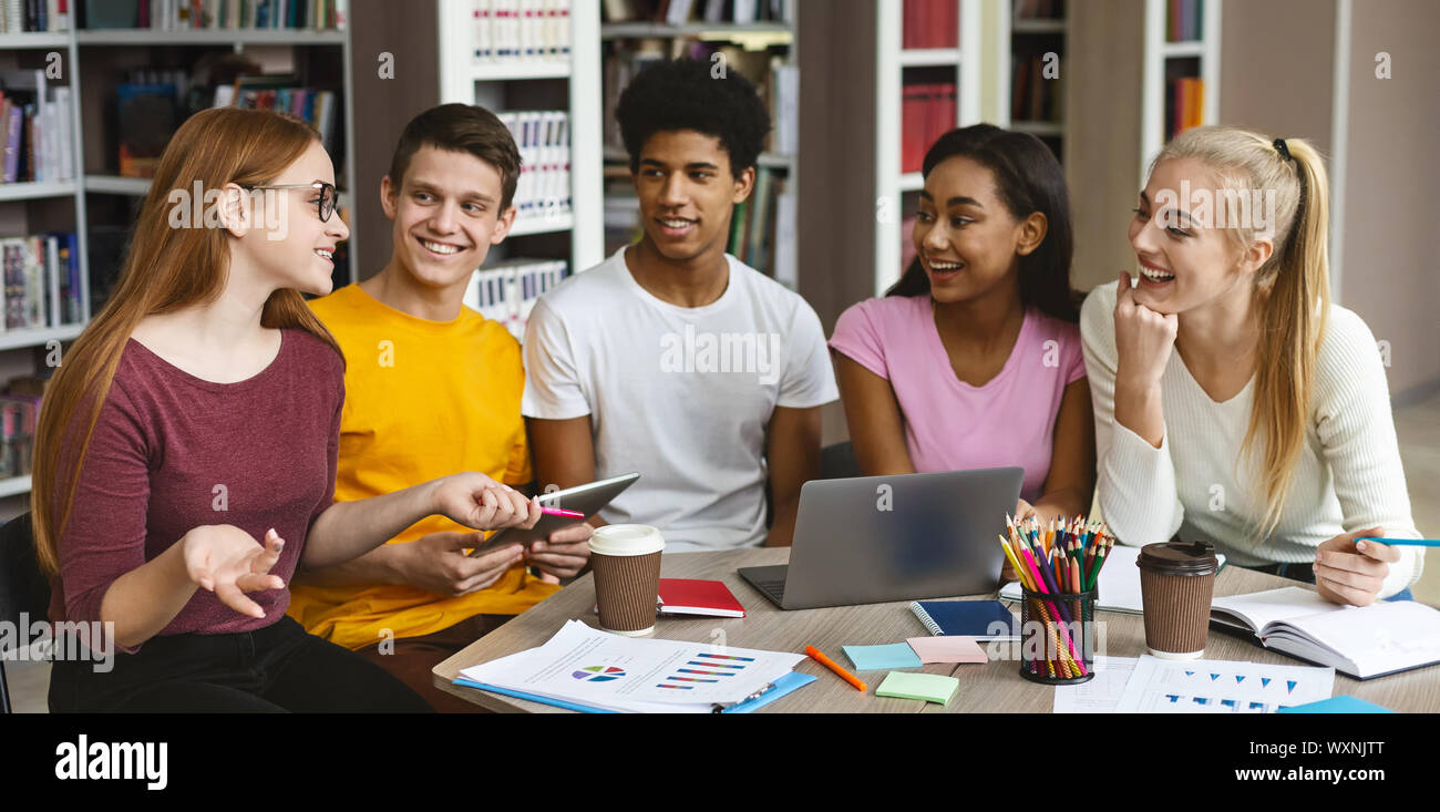 International group of students sitting at library, doing homework ...